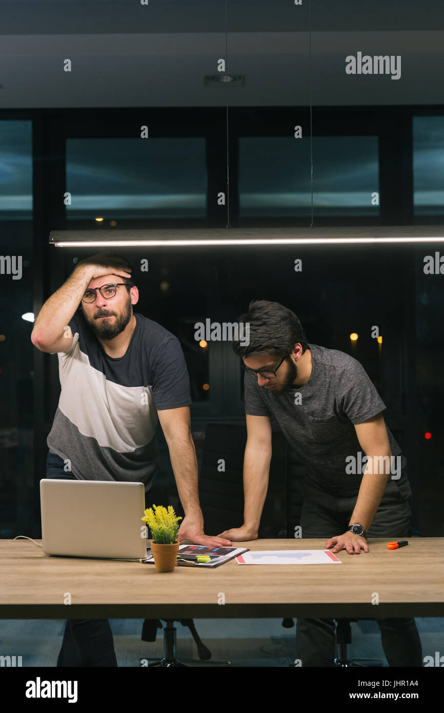 Businessmen consulting at their office in night time working overtime ...