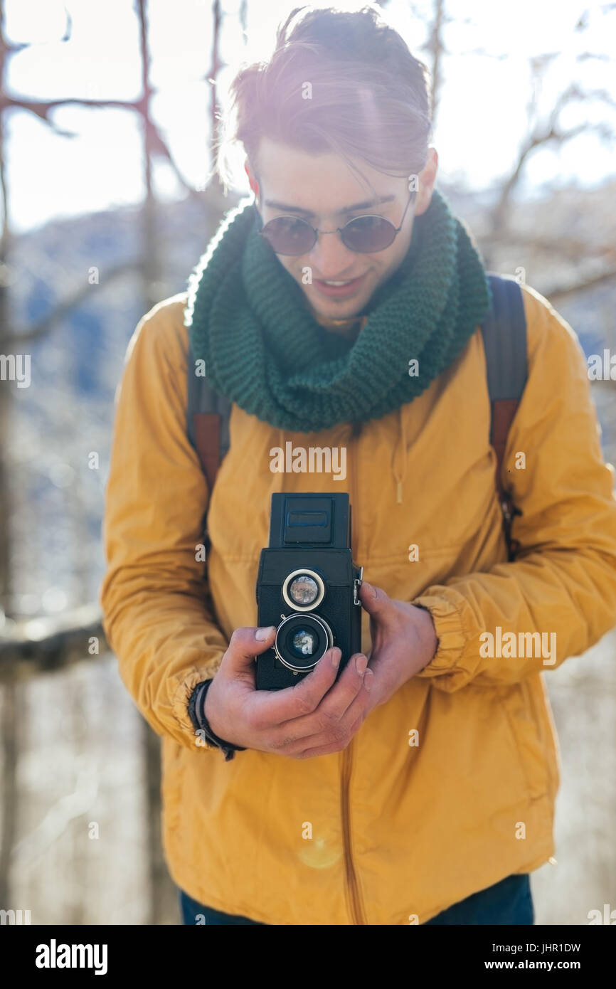 retro stylized photo of young man photographer with vintage camera ...