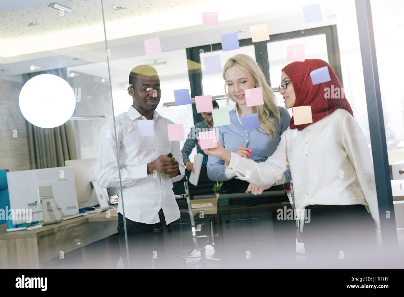 Smiling modern partners looking at sticky notes Stock Photo - Alamy