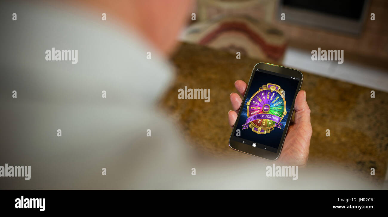 Colorful wheel of fortune on mobile display against cropped image of ...