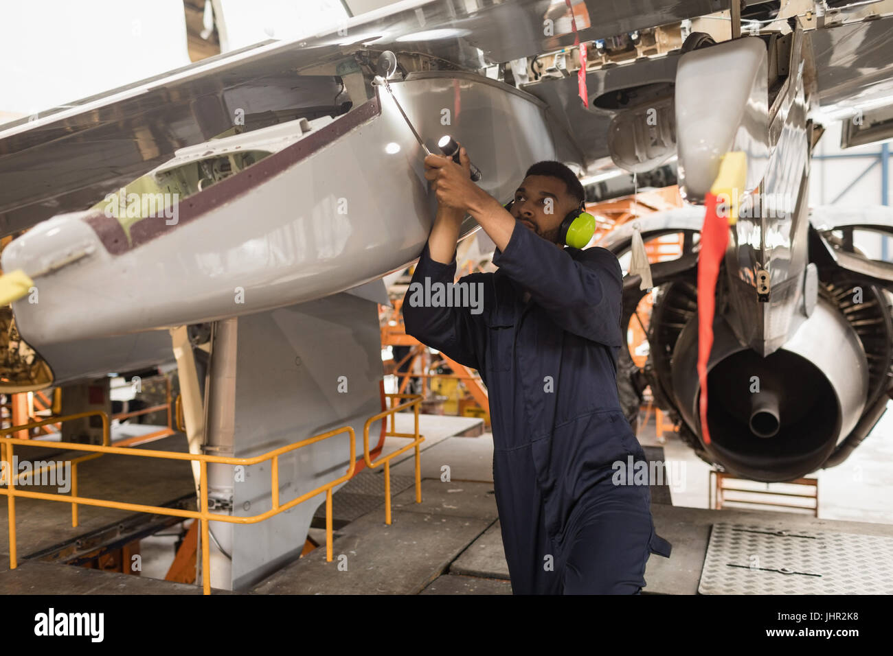 Male aircraft maintenance engineers working over an aircraft at ...