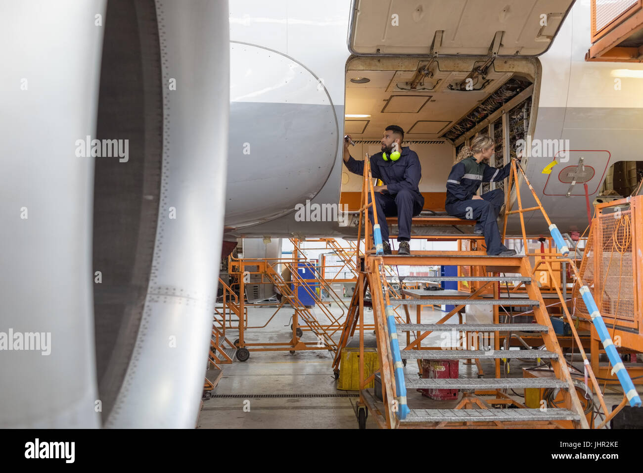 Aircraft maintenance engineers working over an aircraft at airlines ...