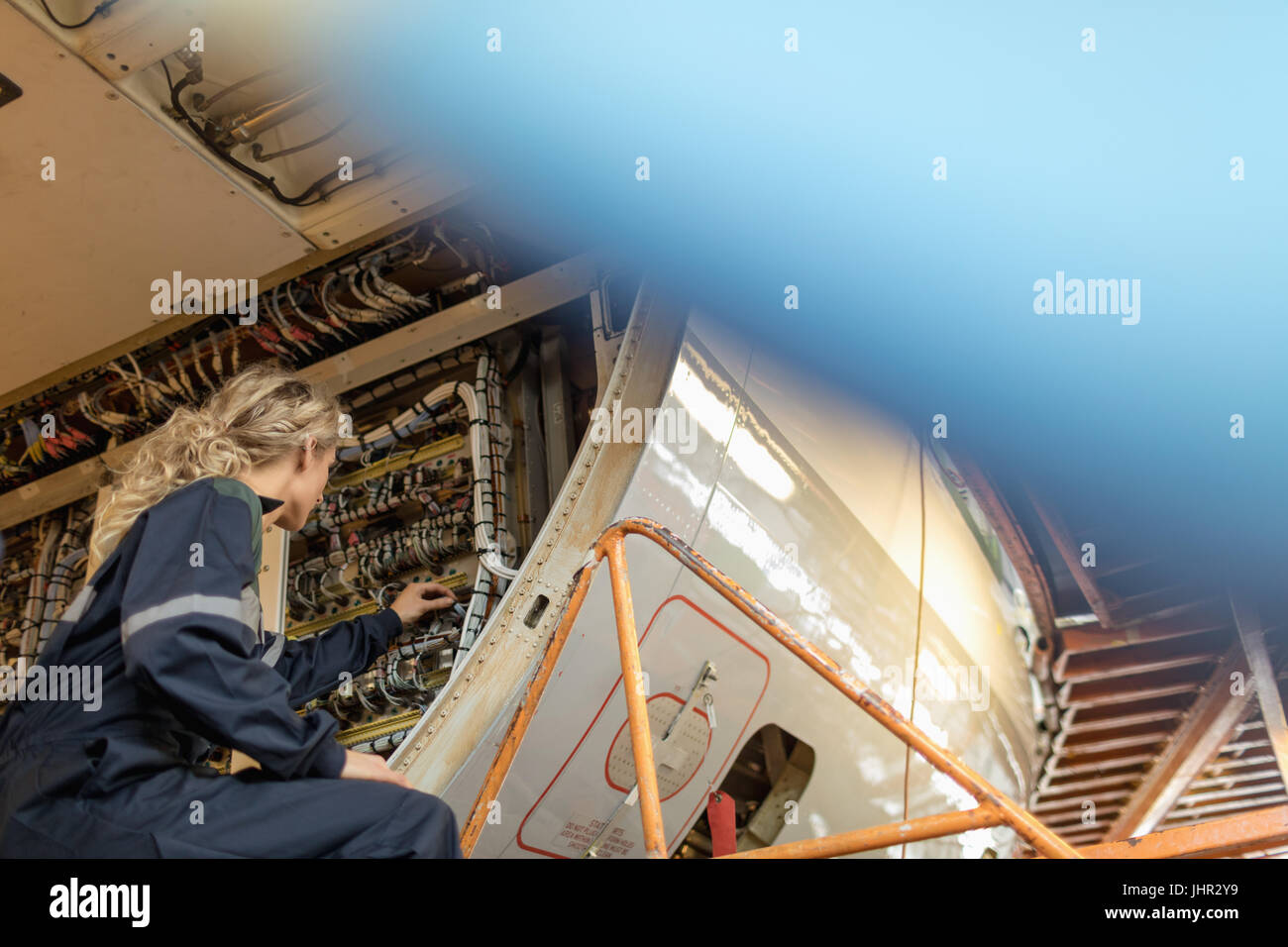 Female aircraft maintenance engineers working over an aircraft engine ...