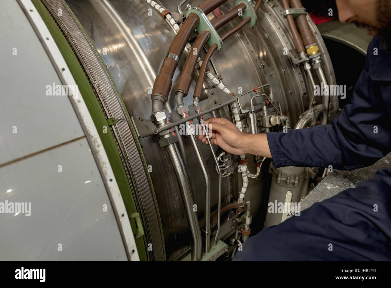 Aircraft maintenance engineer examining turbine engine of aircraft at airlines maintenance ...