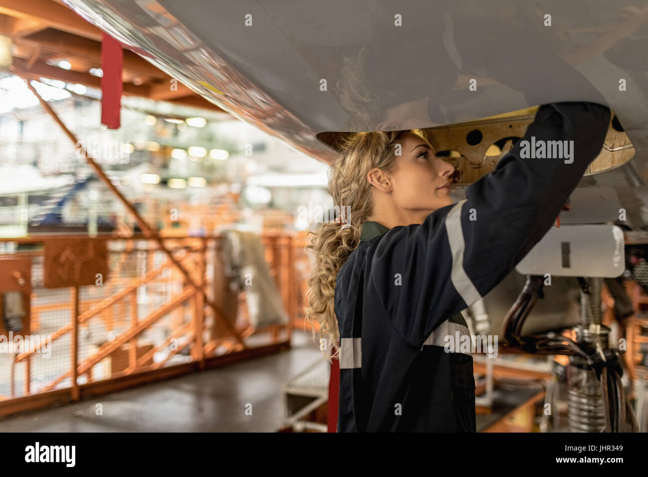 Female aircraft maintenance engineers working over an aircraft engine ...