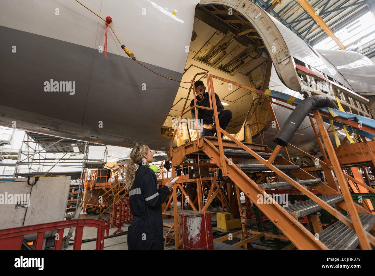 Aircraft maintenance engineers working over an aircraft at airlines ...