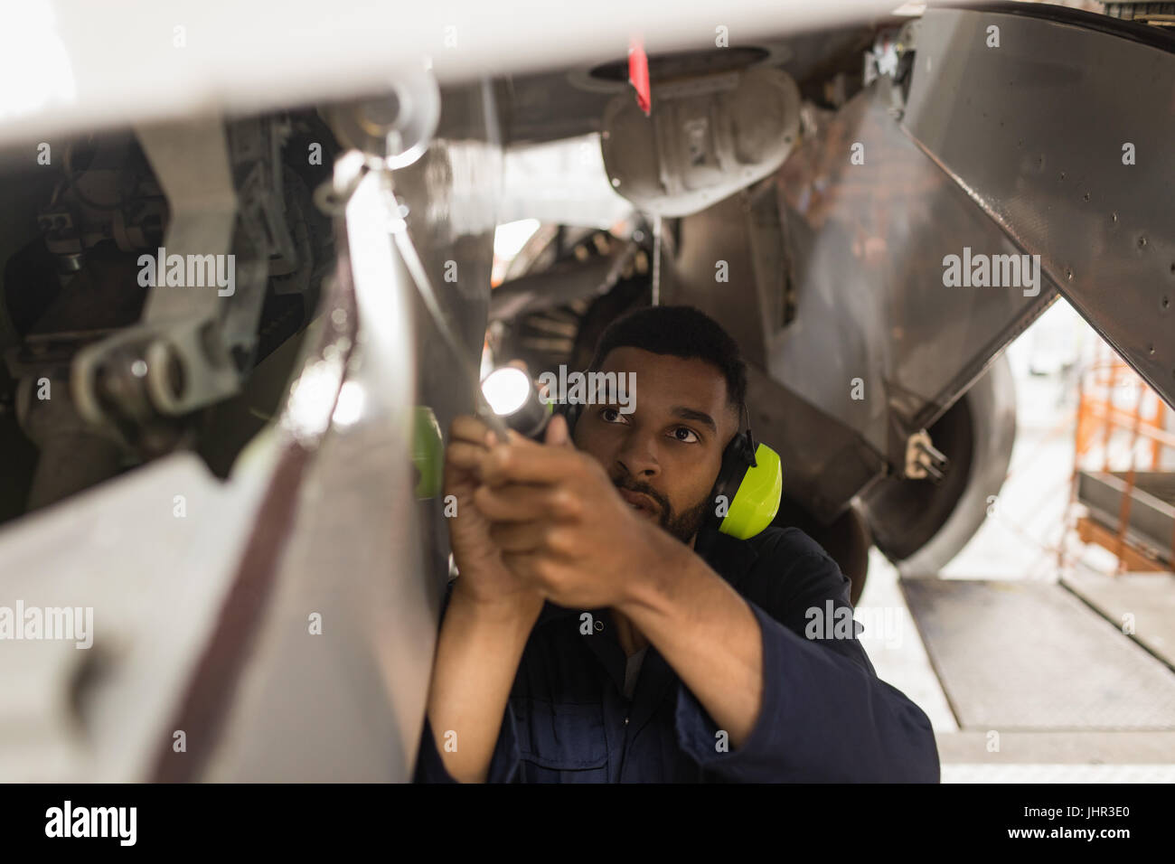 Male aircraft maintenance engineers working over an aircraft at ...