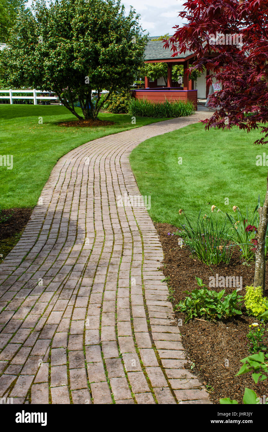 Brick pathway in a park with green lawn Stock Photo - Alamy