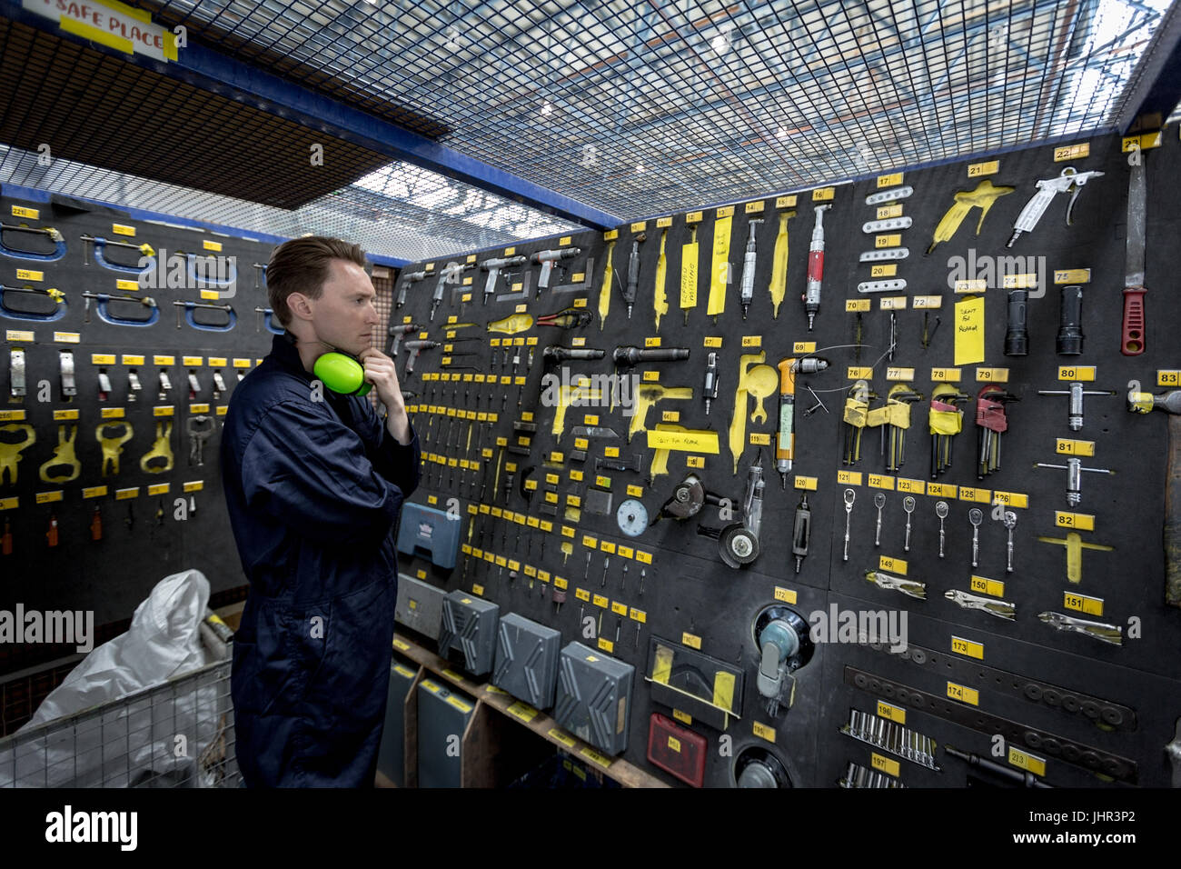 Male aircraft maintenance engineer examining various work tool at airlines maintenance facility ...