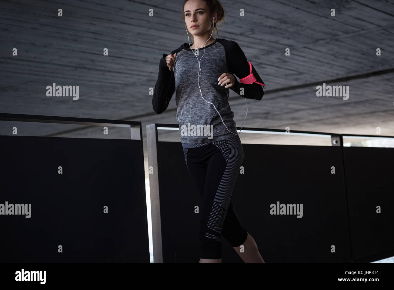 Fit woman jogging in basement Stock Photo - Alamy