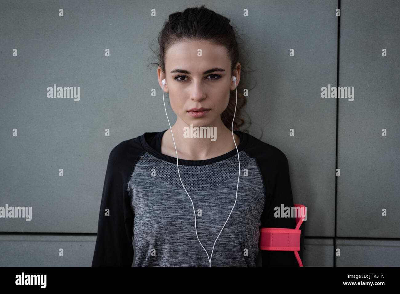 Woman leaning against wall listening hi-res stock photography and ...