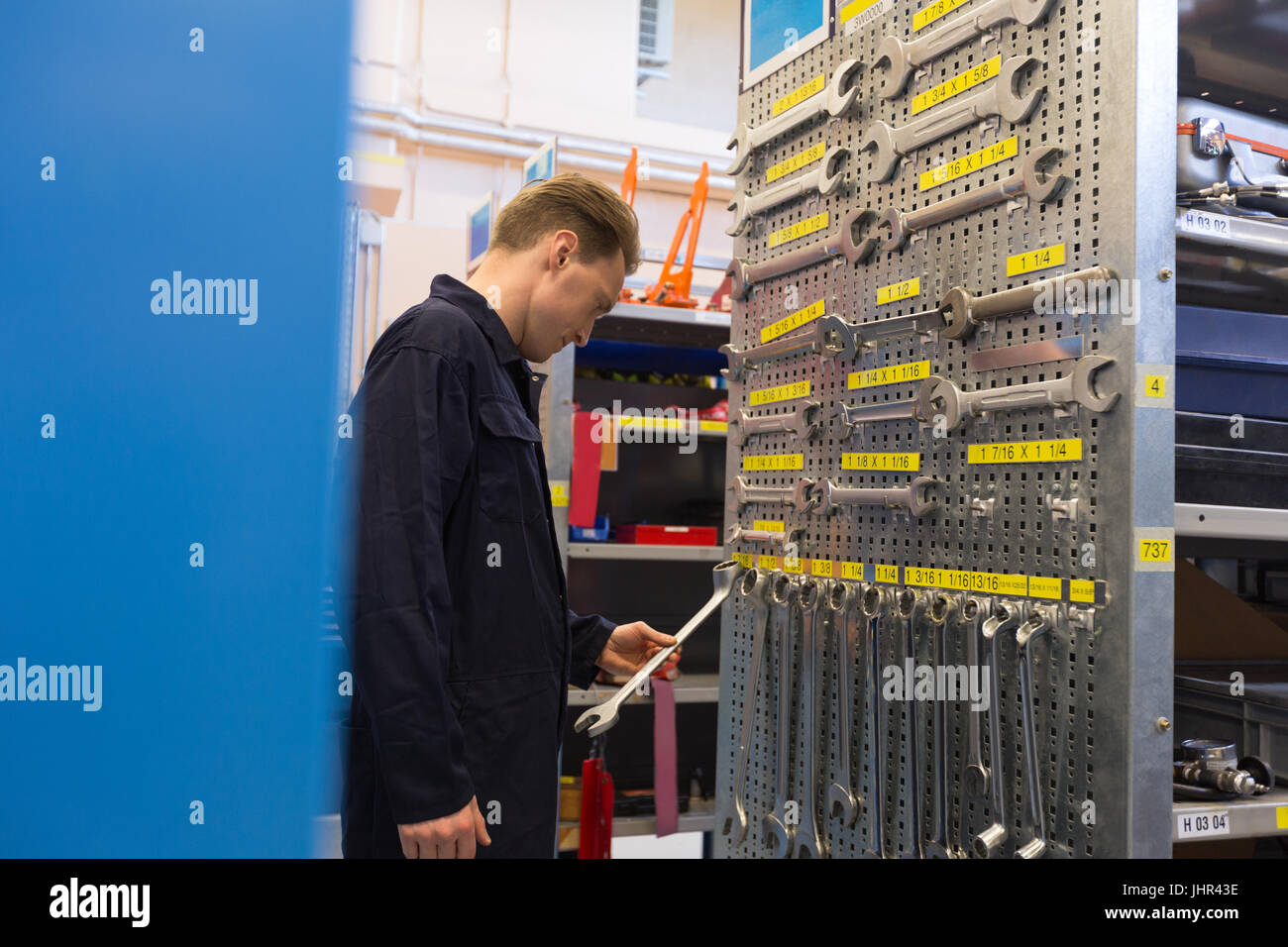 Male aircraft maintenance engineer examining various work tool at ...