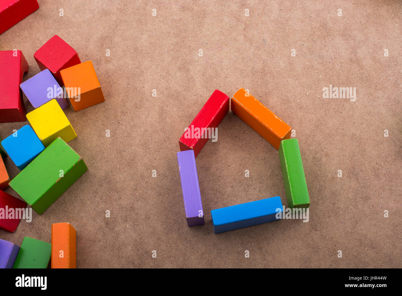 House shape formed out of building blocks on a brown background Stock ...
