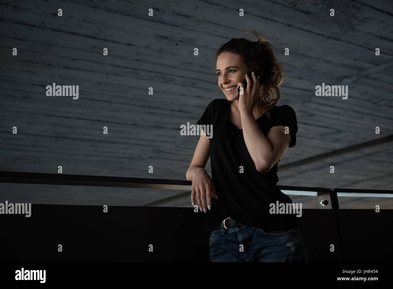 Beautiful woman talking mobile phone in basement Stock Photo - Alamy