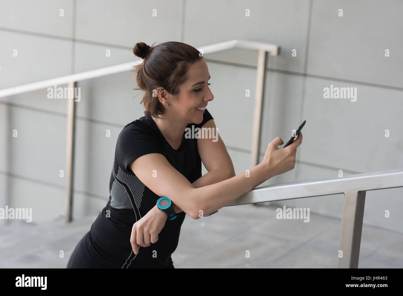 Fit woman using mobile phone on staircase Stock Photo - Alamy