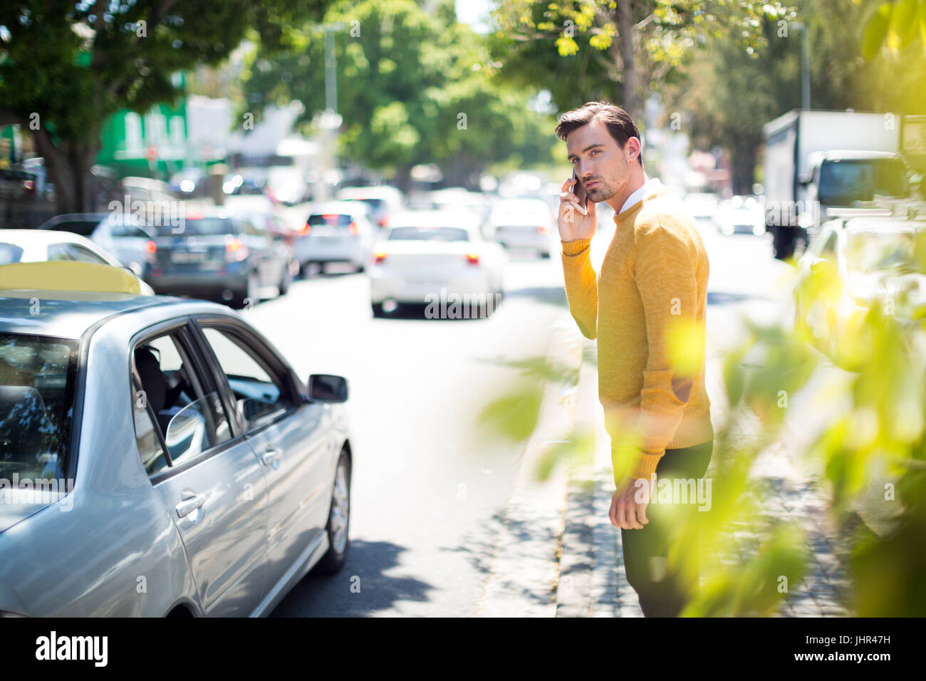 Man talking on mobile phone while crossing road Stock Photo - Alamy