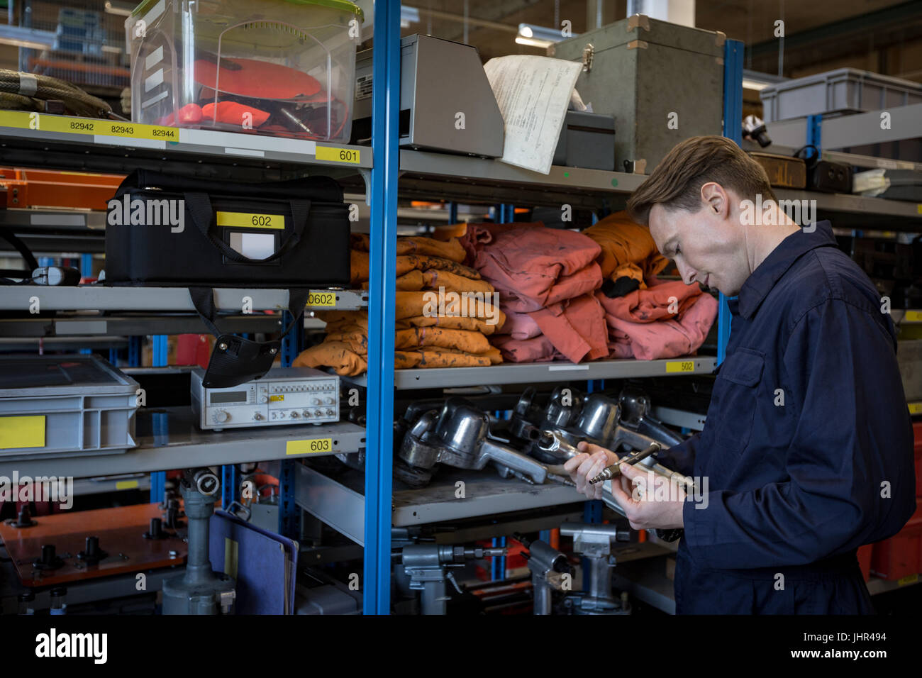 Male aircraft maintenance engineer examining various work tool at ...
