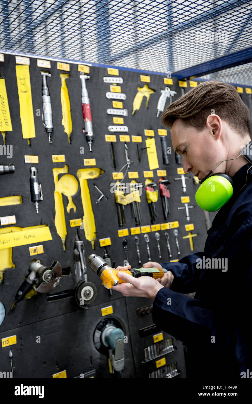 Male aircraft maintenance engineer examining various work tool at ...