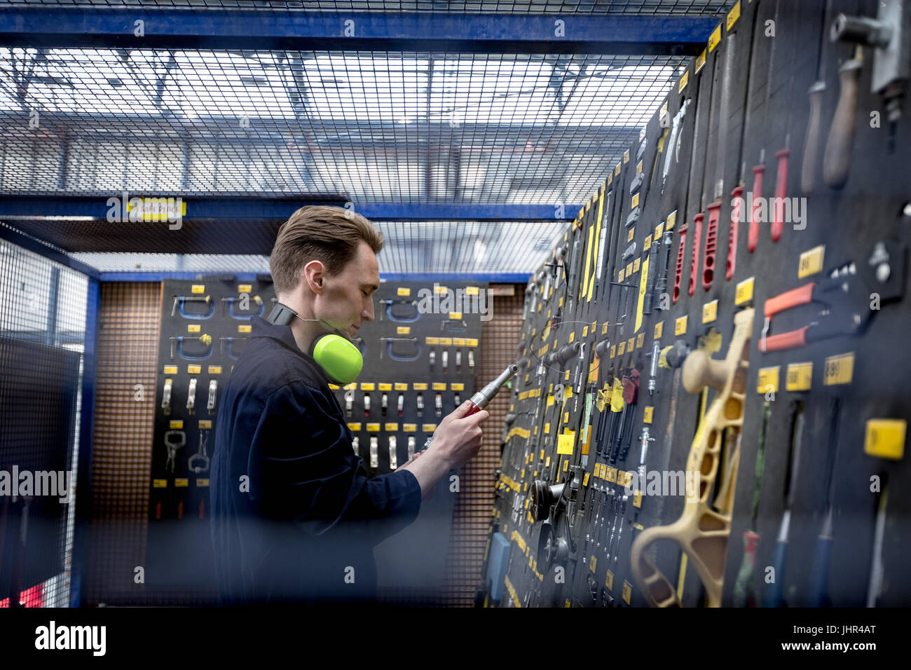 Male aircraft maintenance engineer examining various work tool at ...