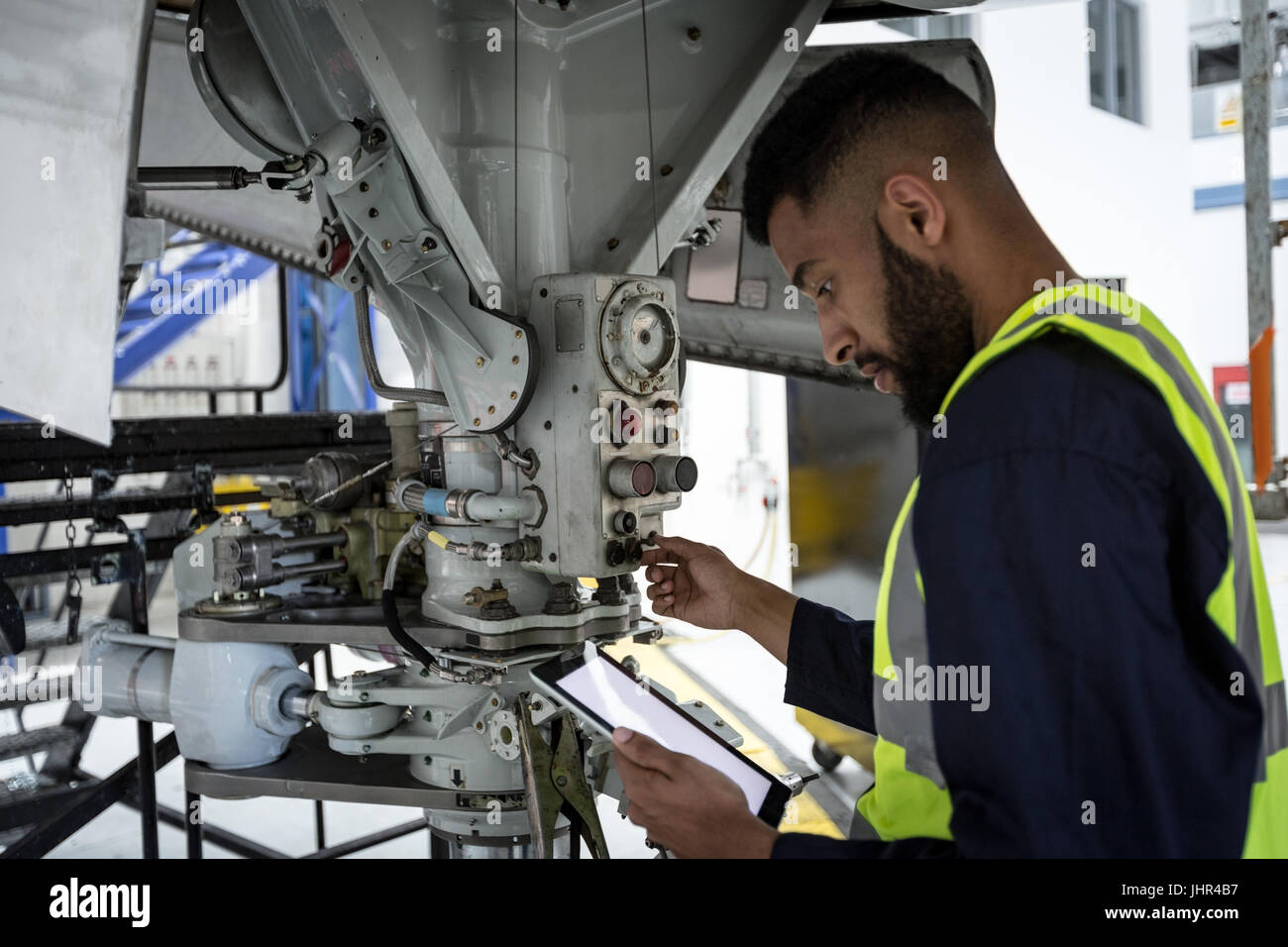 Male aircraft maintenance engineer examining engine of an aircraft at airlines maintenance ...