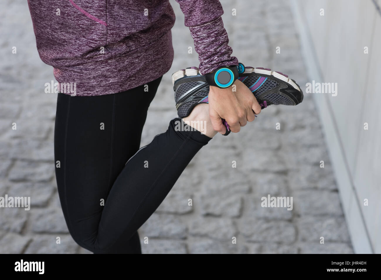 Mid section of fit woman performing stretching exercise outside ...