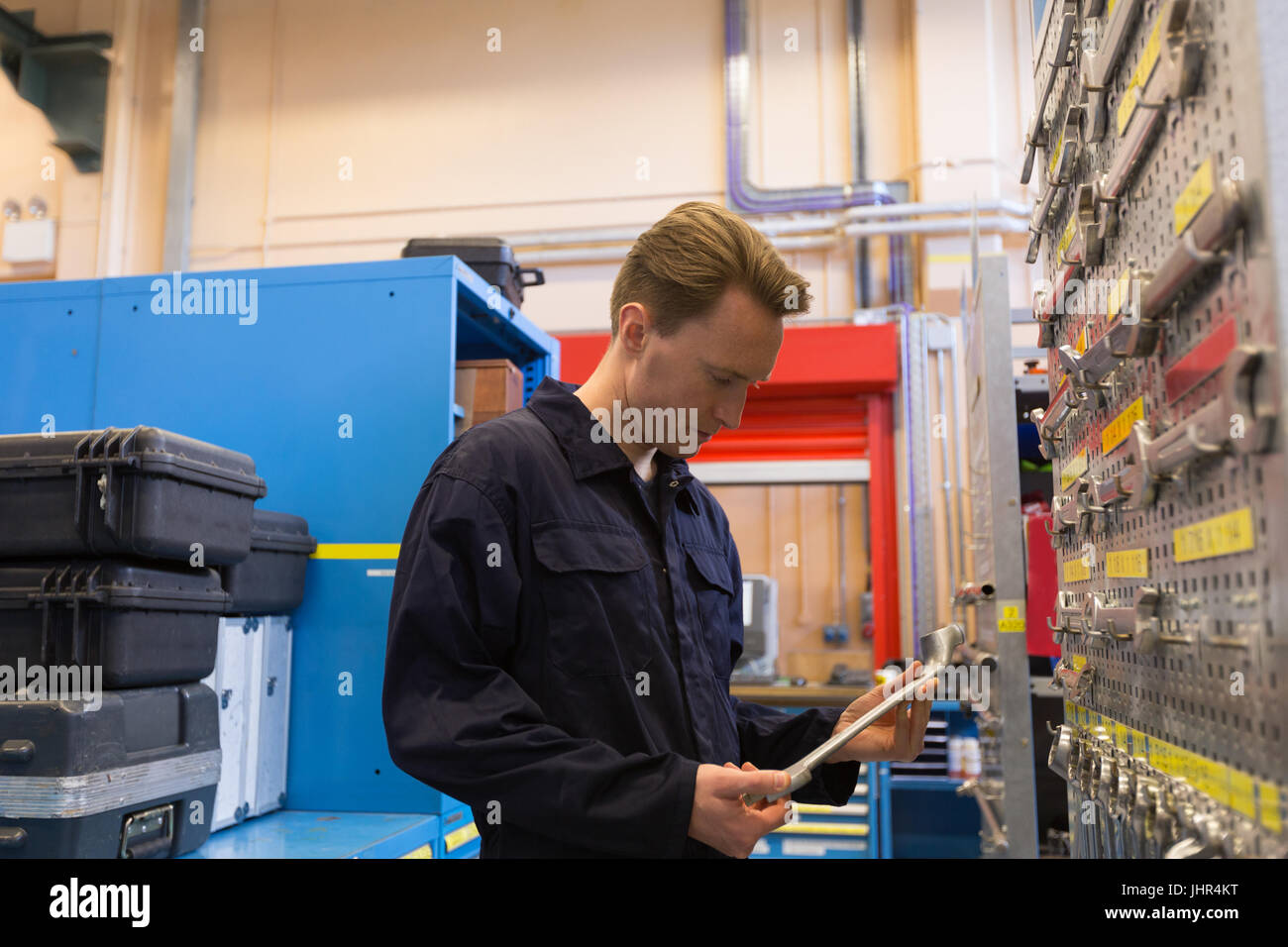 Male aircraft maintenance engineer examining various work tool at airlines maintenance facility ...