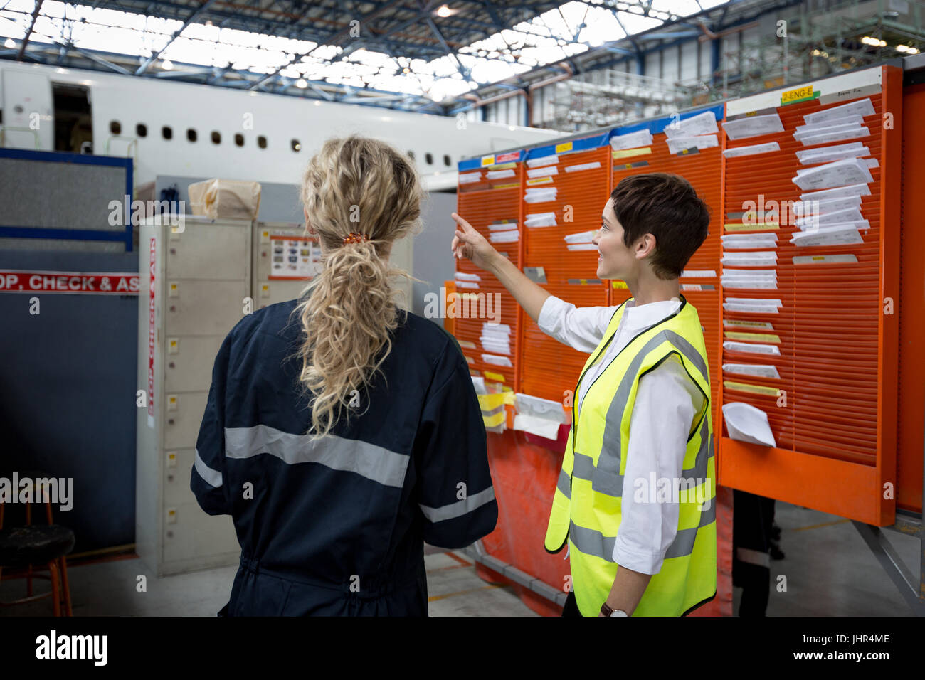 Female maintenance engineers interacting with each other at airlines ...