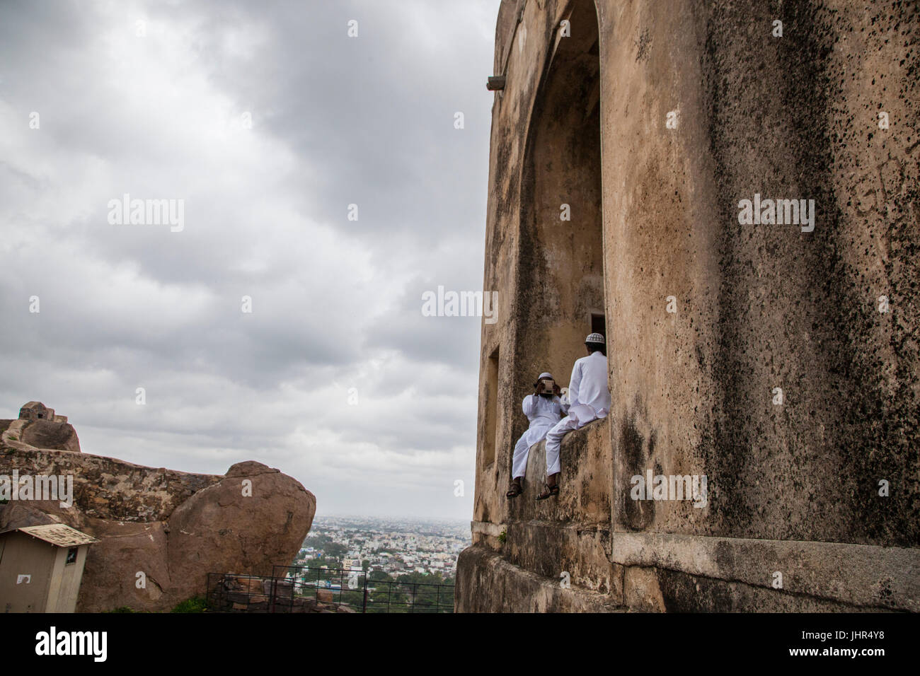 Two friends rest in traditional clothes on top of Golconda Fort, while ...