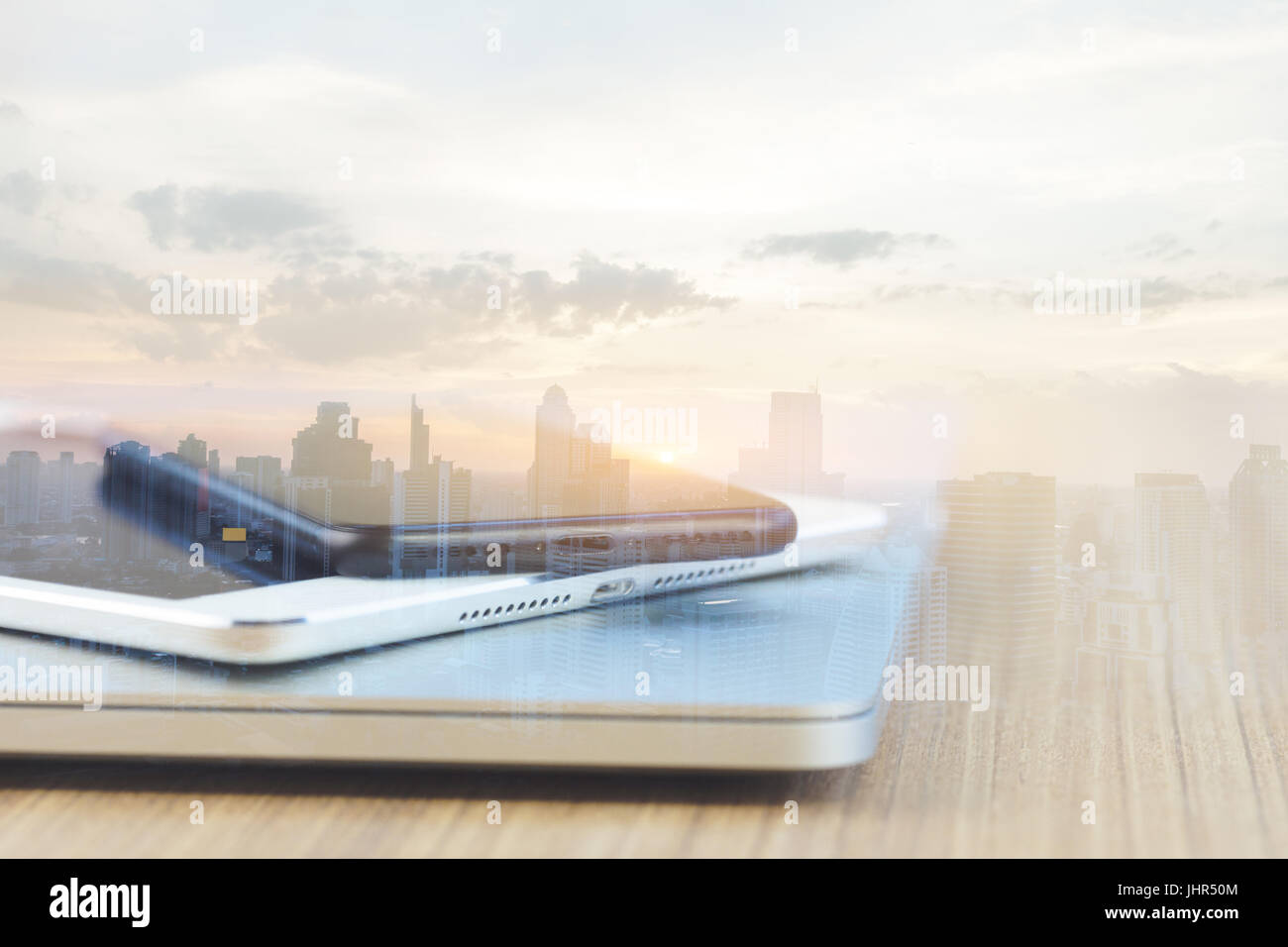 communication device stack on desk and city background reflect modern ...