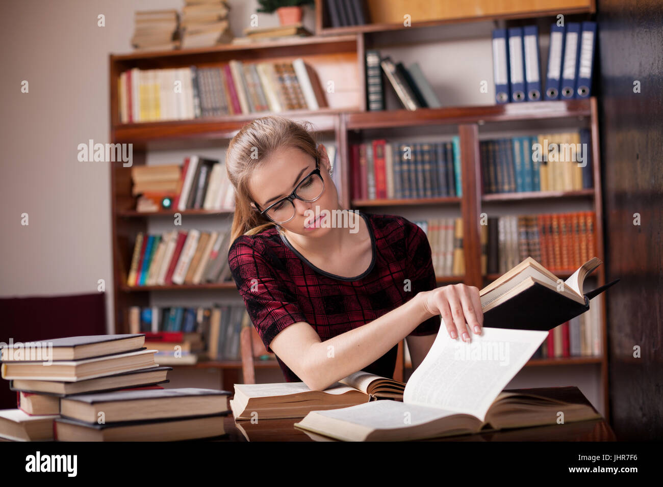 girl student sits in the library reading and preparing for the exam ...