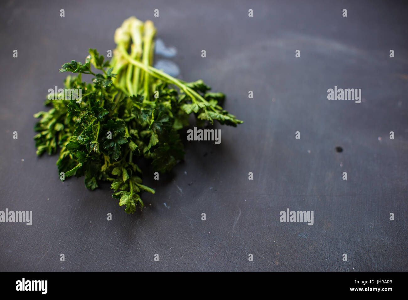 Fresh parsey herb on dark background with copyspace Stock Photo - Alamy