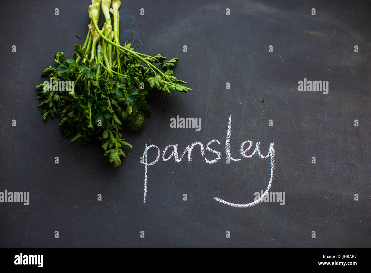 Fresh parsey herb on dark background with copyspace Stock Photo - Alamy