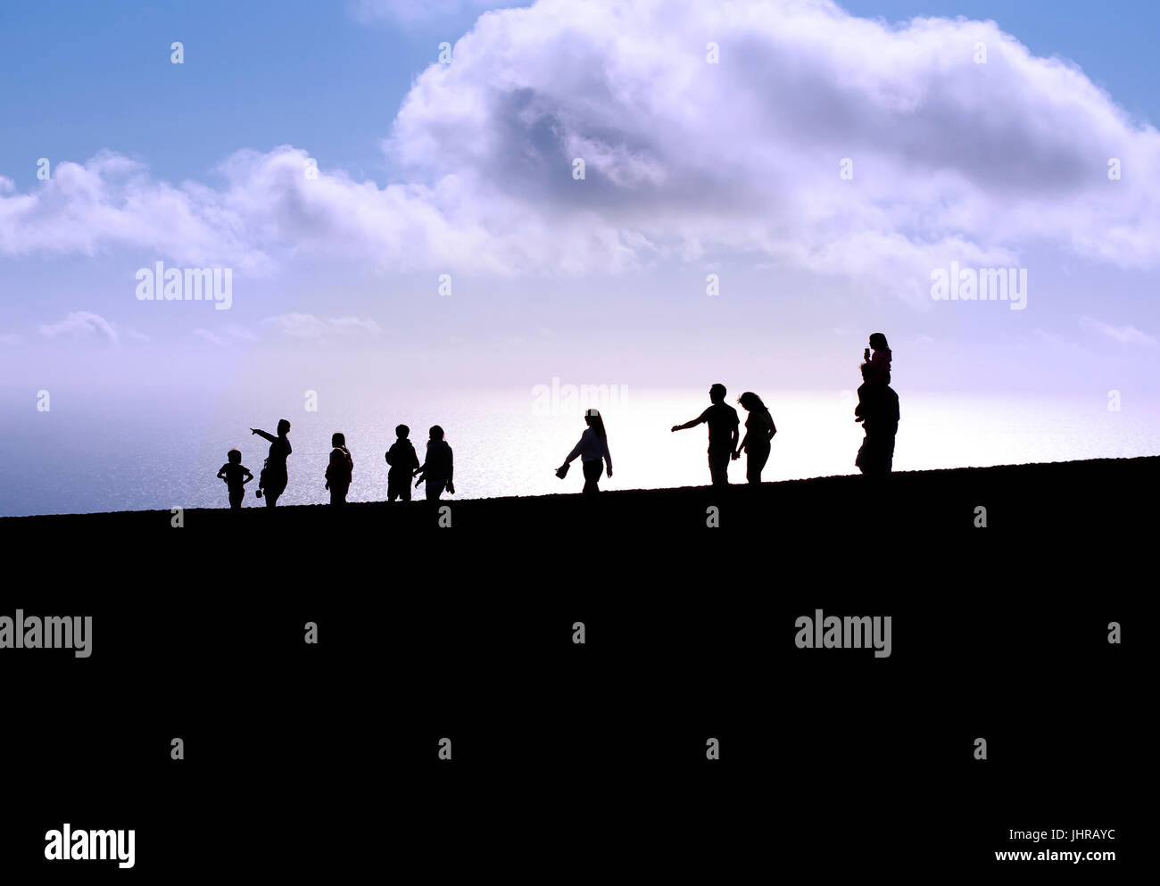 High contrast photo of the silhouettes of a group of people walking ...