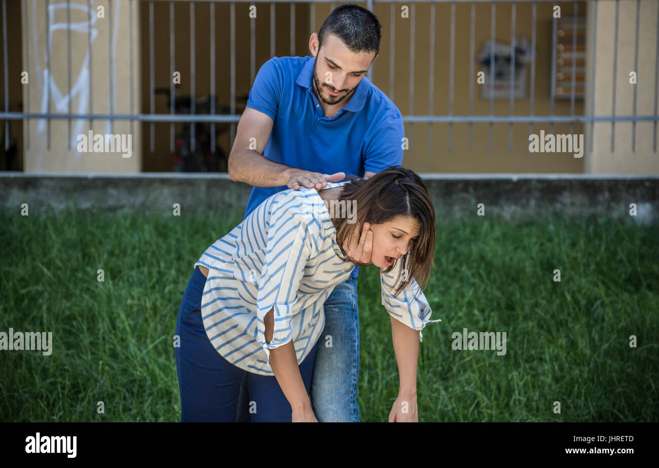 Guy Making The Heimlich Maneuver To A Girl While Shes Choking Stock