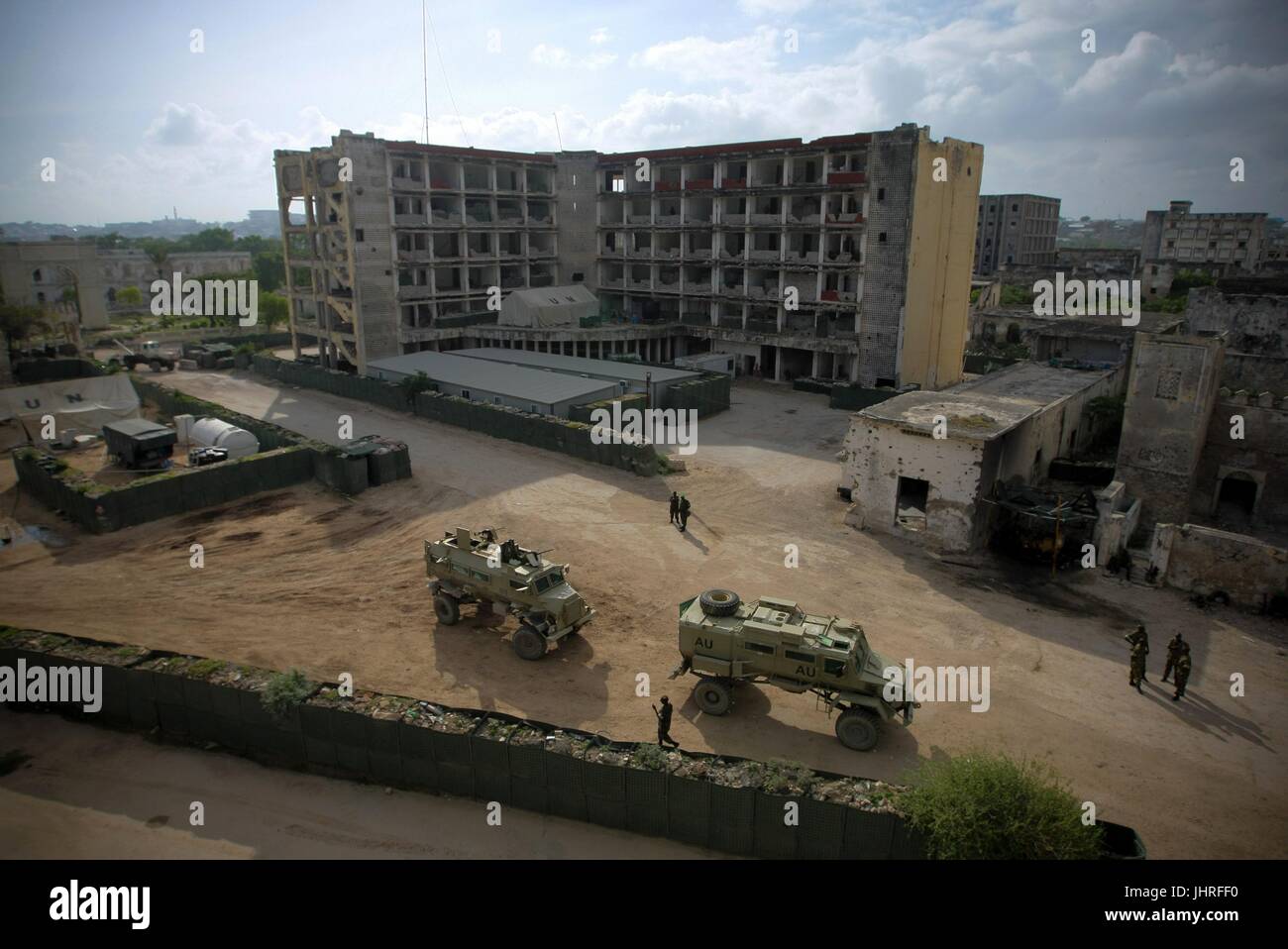 Somalian military personnel trucks park in front of a war-damaged ...