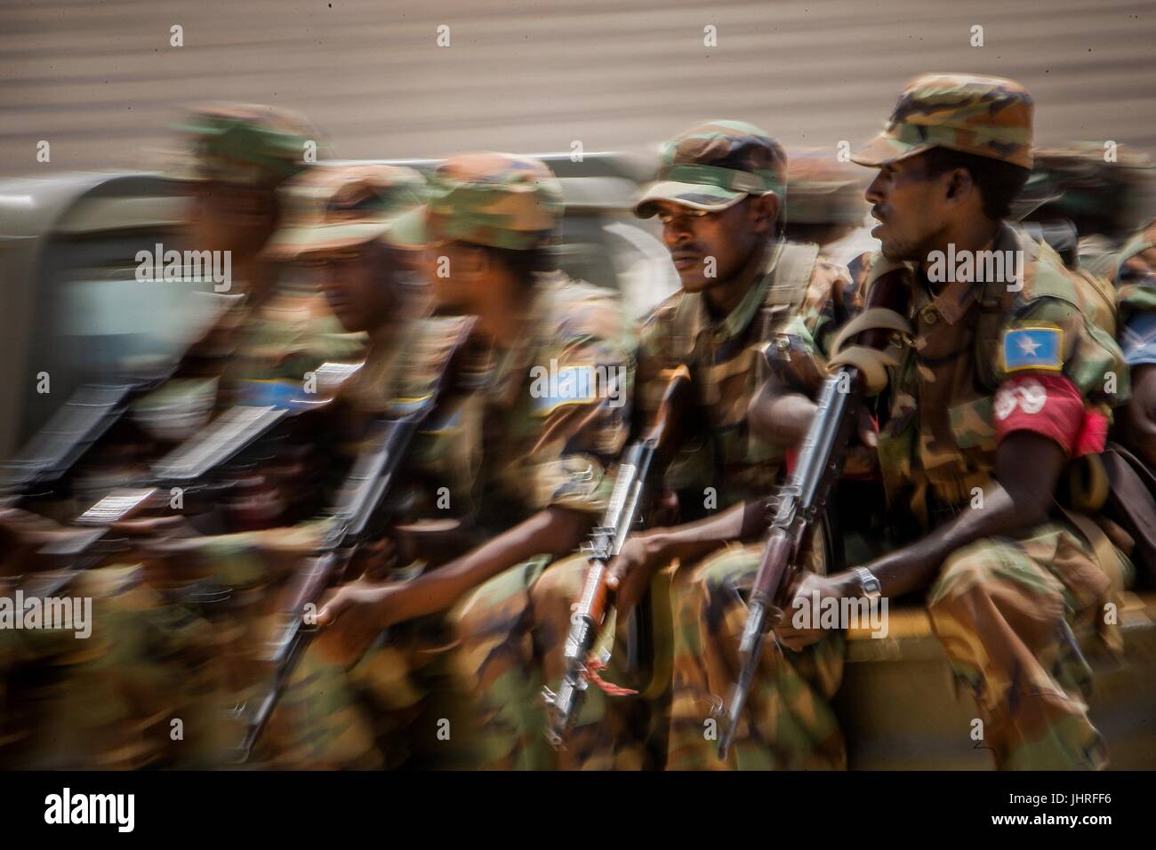 Somali National Army soldiers ride in the back of a pick-up truck ...