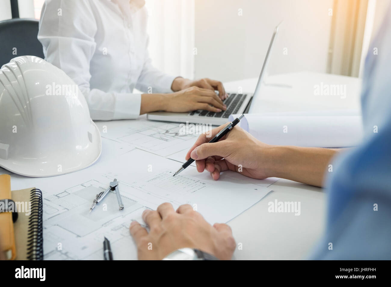 Architects engineer discussing at the table with blueprint - Closeup on ...