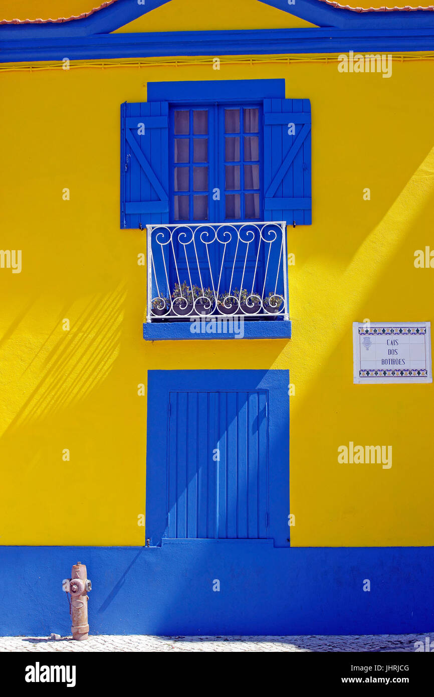 Bright yellow building with deep blue trim wall facade building along ...