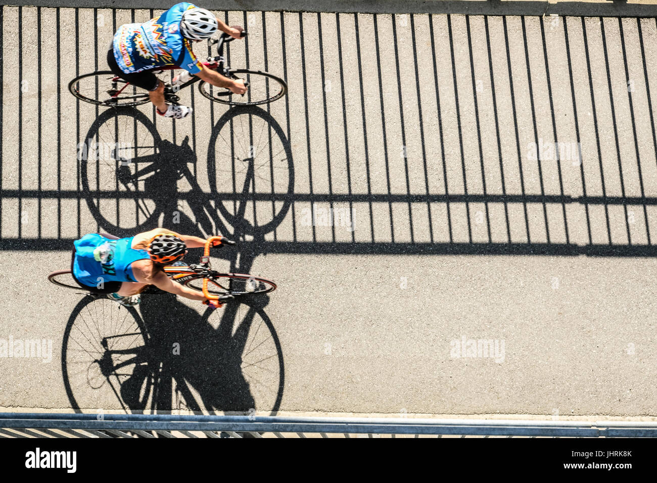 An overhead view of blurred cyclists on a path with strong patterned ...