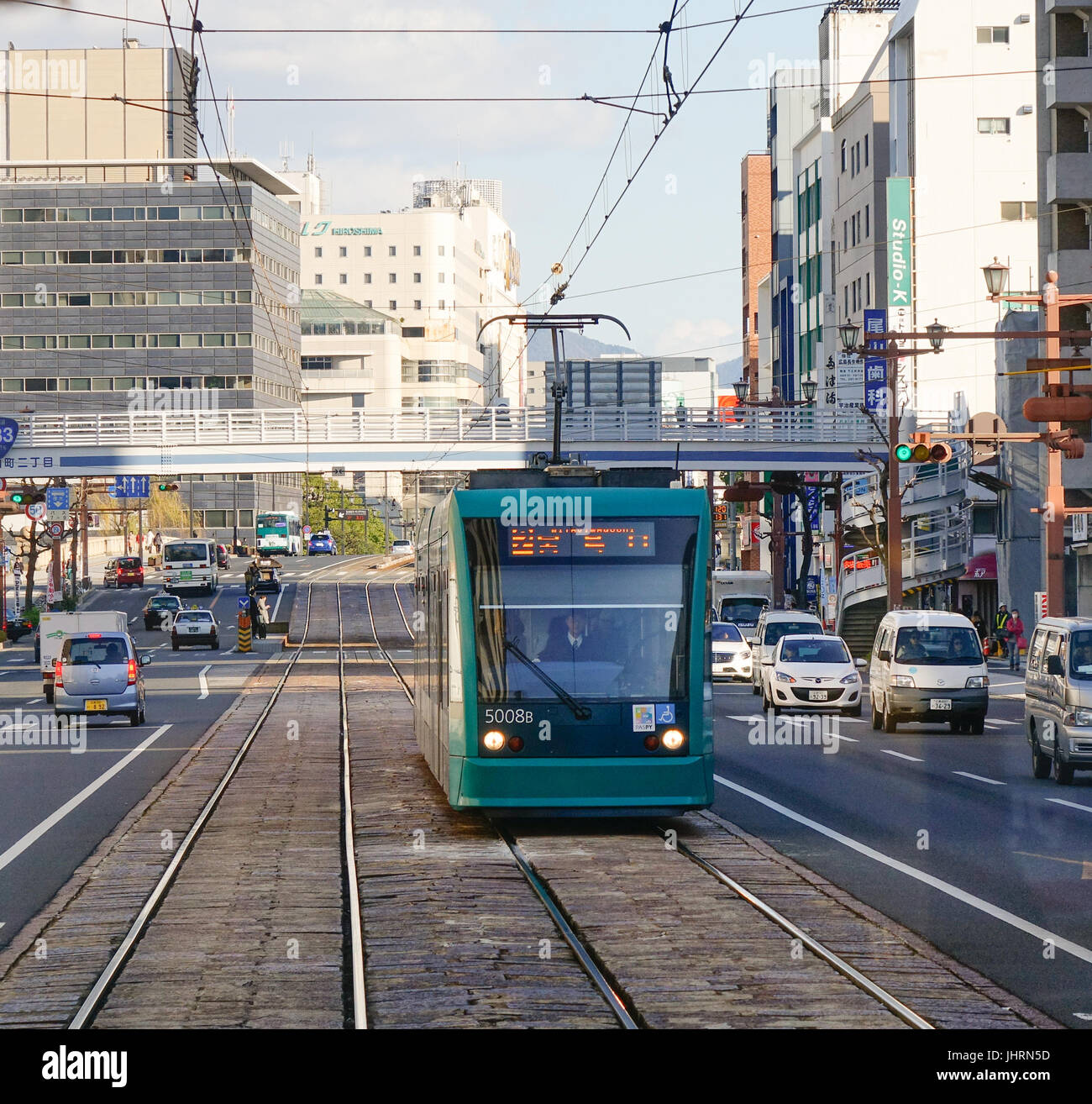 Hiroshima, Japan - Dec 28, 2015. A green streetcar (tram) running on ...