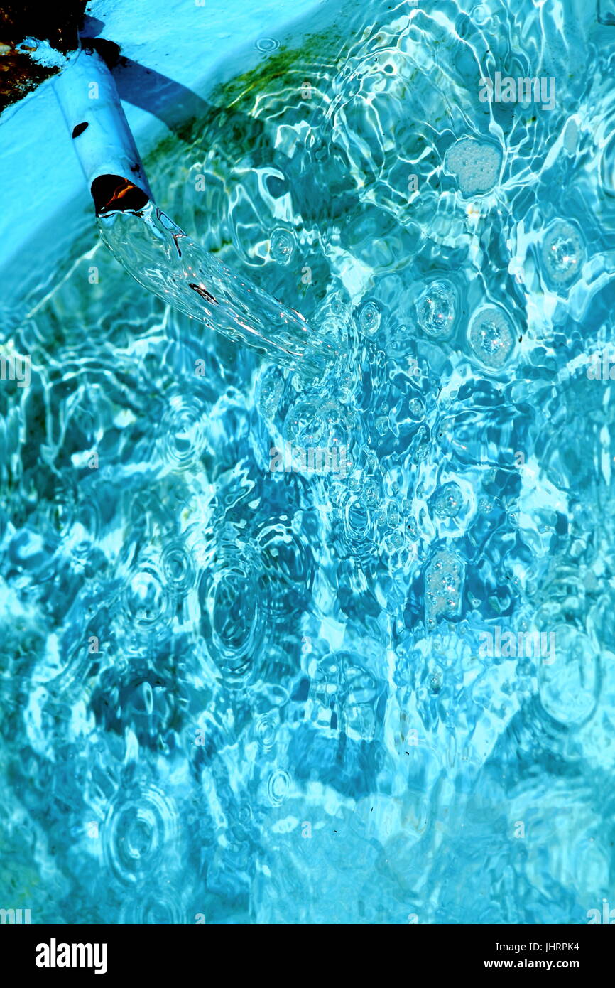 Swirling cyan blue water with light waves and spots. Fragment of a ...