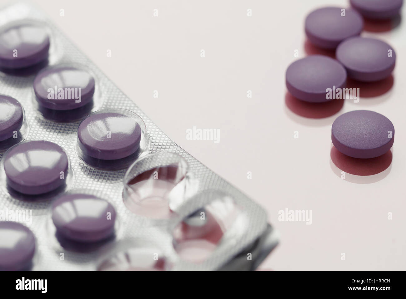 Close-up of purple pills in a pack on a pink background Stock Photo - Alamy