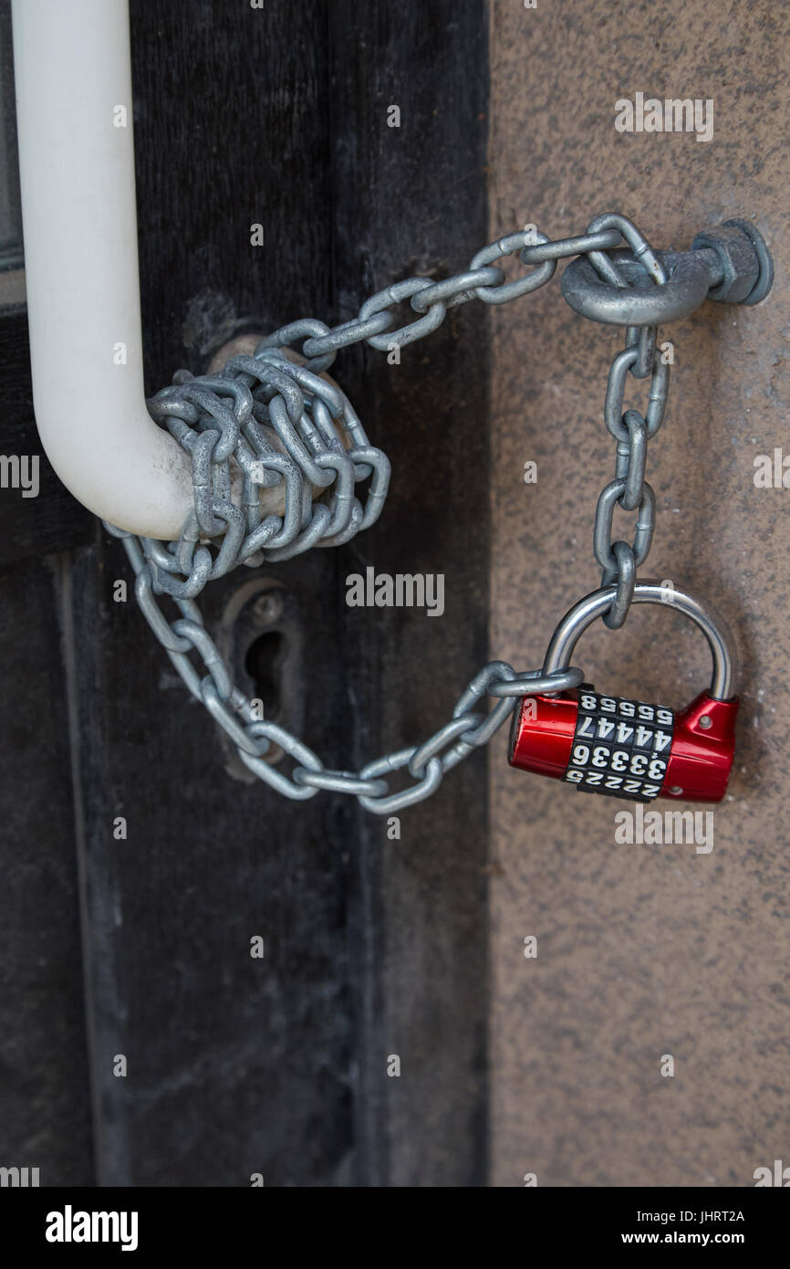 Door closed on the chain with a coded lock Stock Photo - Alamy