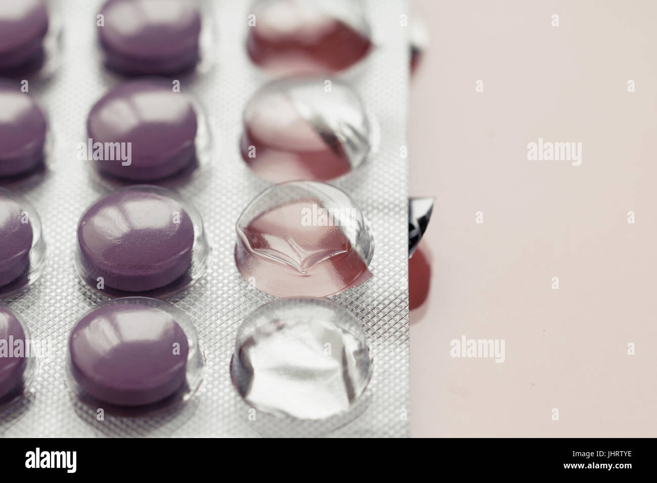 Close-up of purple pills in a pack on a pink background Stock Photo - Alamy