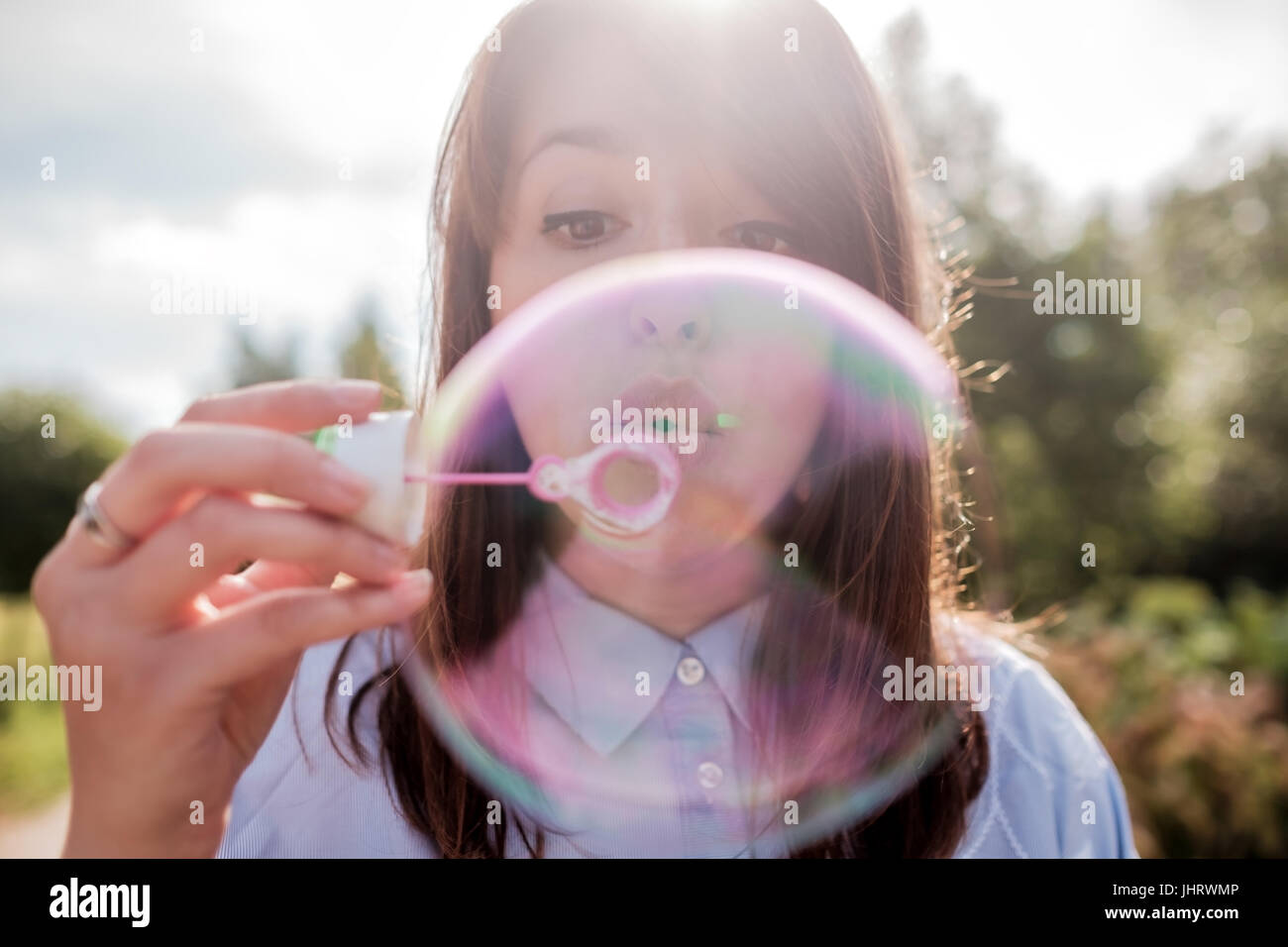 Girl blowing bubbles outdoor. Focus on lips Stock Photo - Alamy
