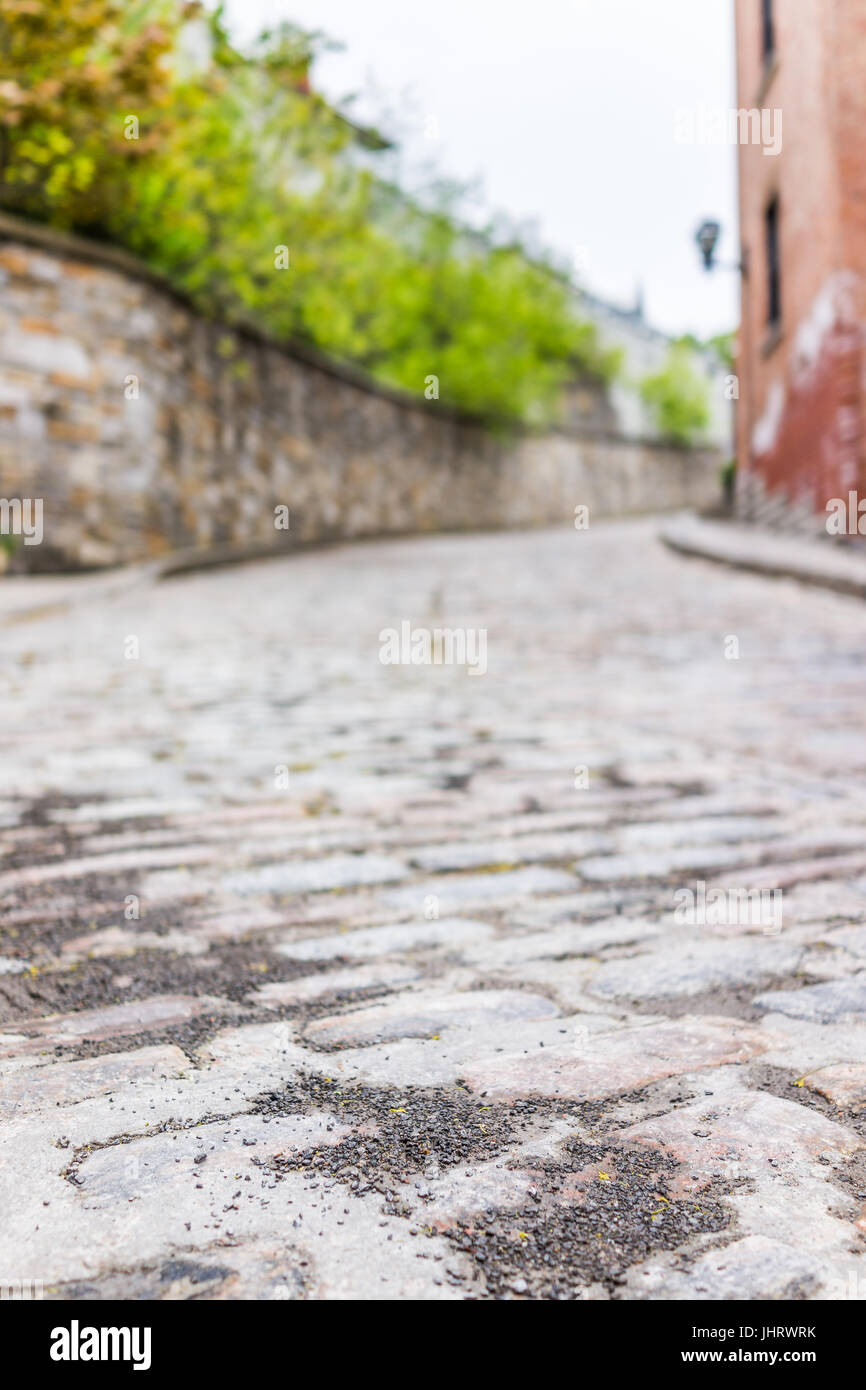 Lower old town narrow street with cobblestone road on incline uphill ...