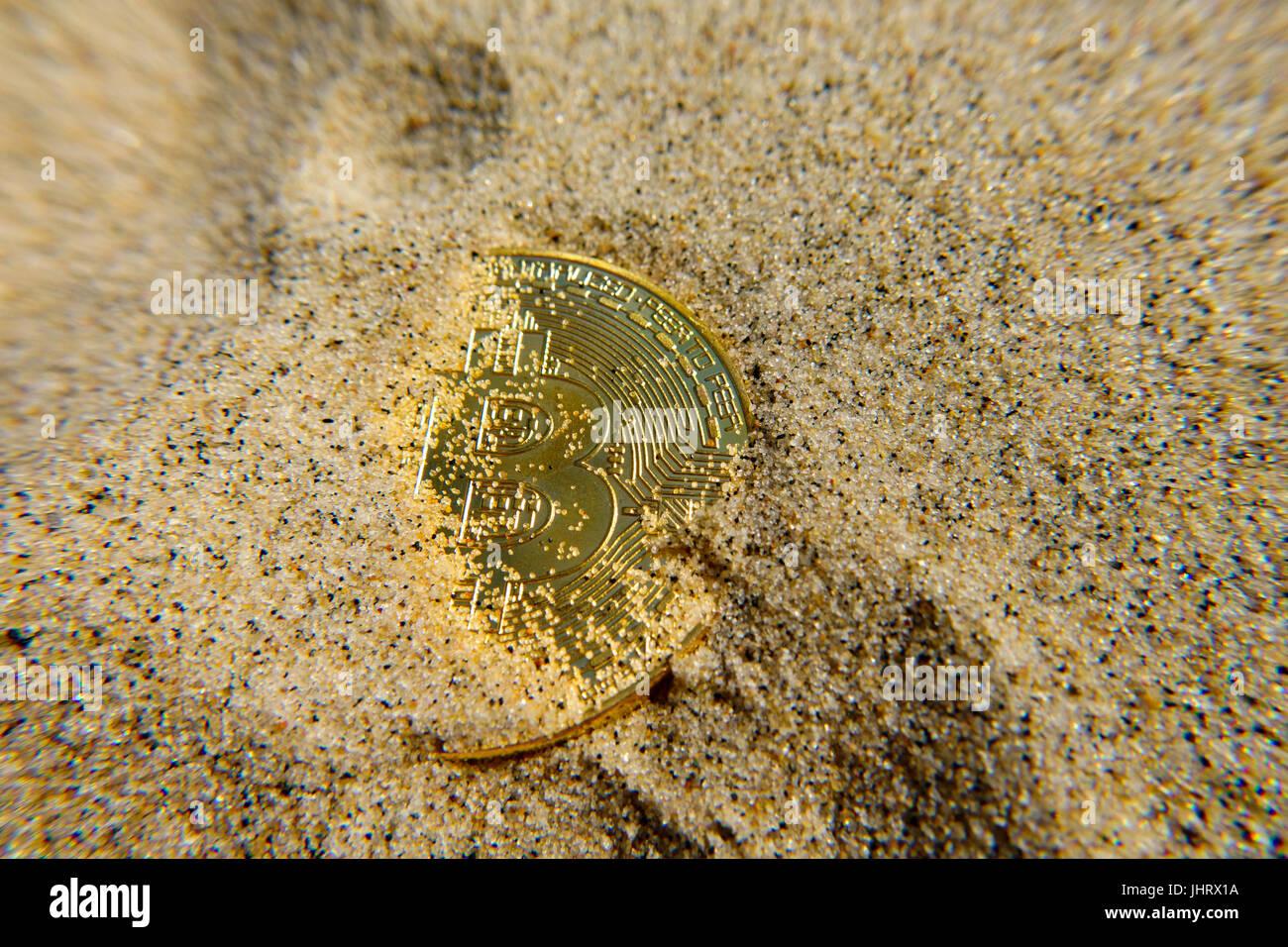 Golden bitcoin coin is in the sand Stock Photo - Alamy