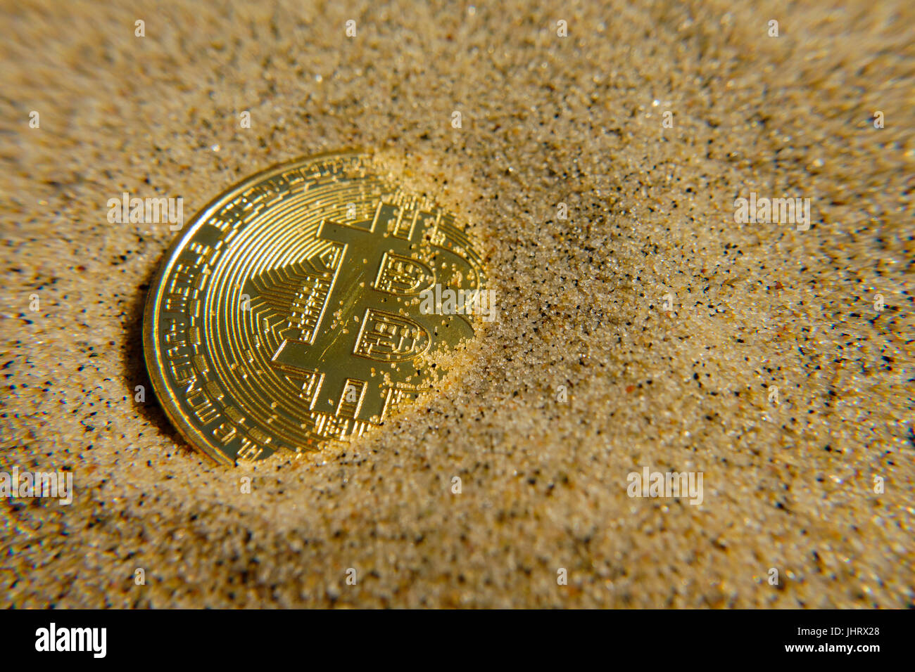 Golden bitcoin coin is in the sand Stock Photo - Alamy