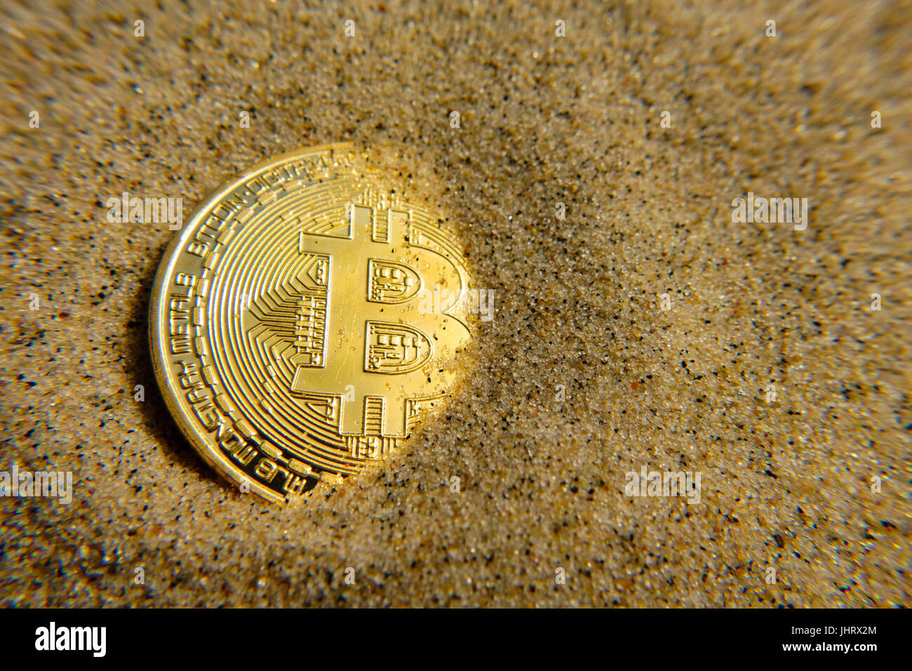 Golden bitcoin coin is in the sand Stock Photo - Alamy