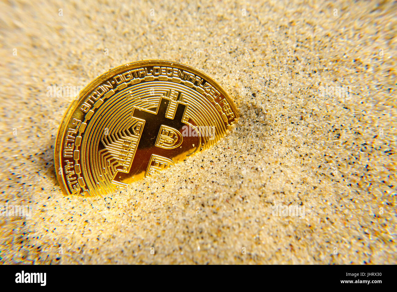 Golden bitcoin coin is in the sand Stock Photo - Alamy